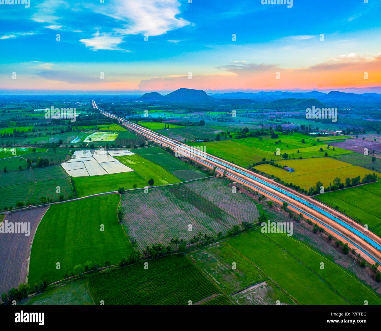 aerial view scenery sunset on new route pass in the rice field. under ...