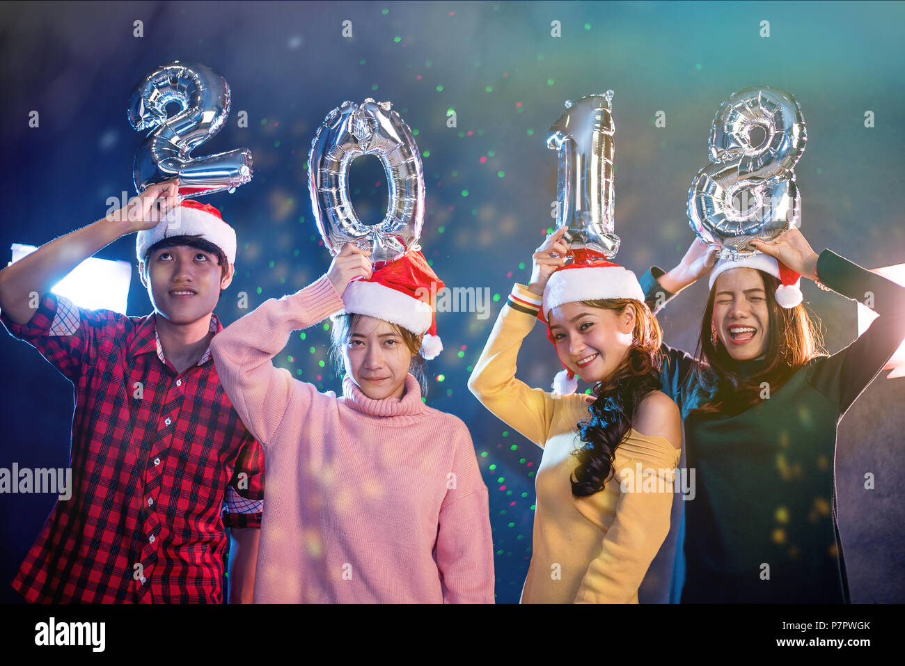 "2018" Letter text is held by party people. Happy New Year 2018 party ...