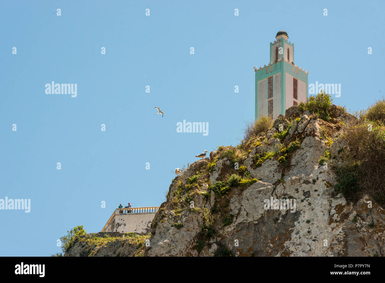 The minaret of the mosque and two people at the lookout on top of the ...