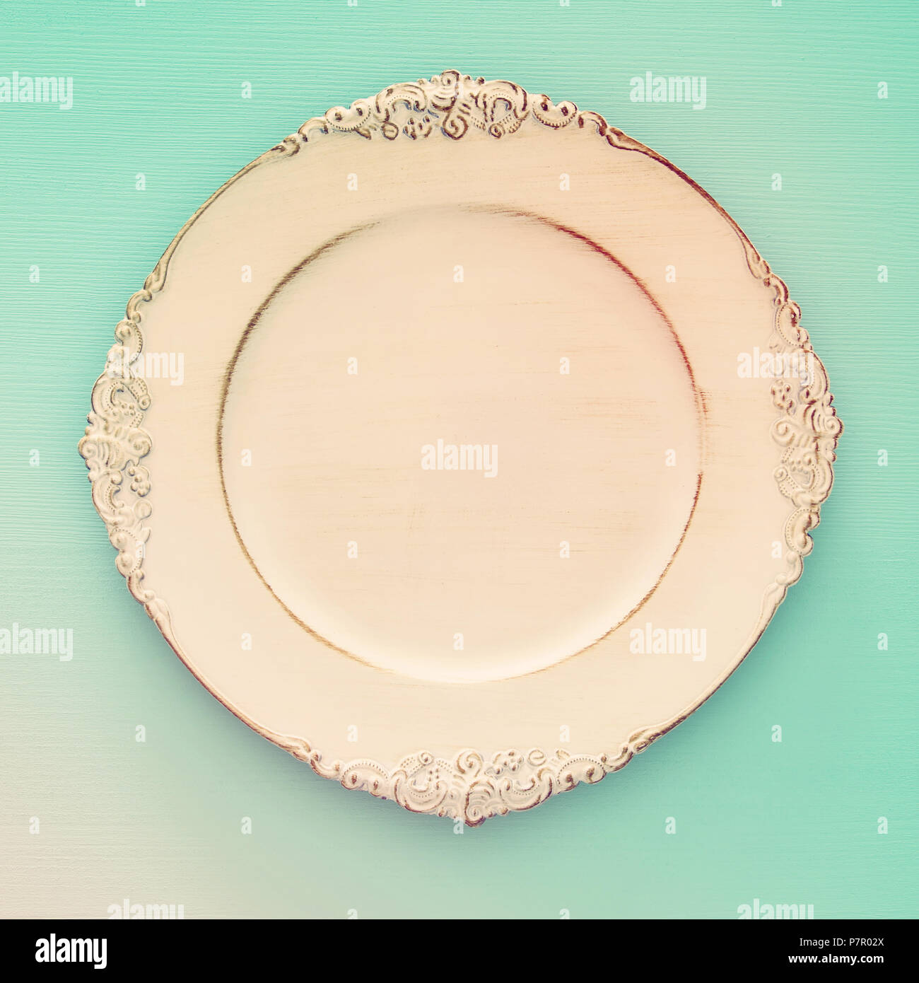 Top view of vintage white empty plate over blue mint wooden background ...