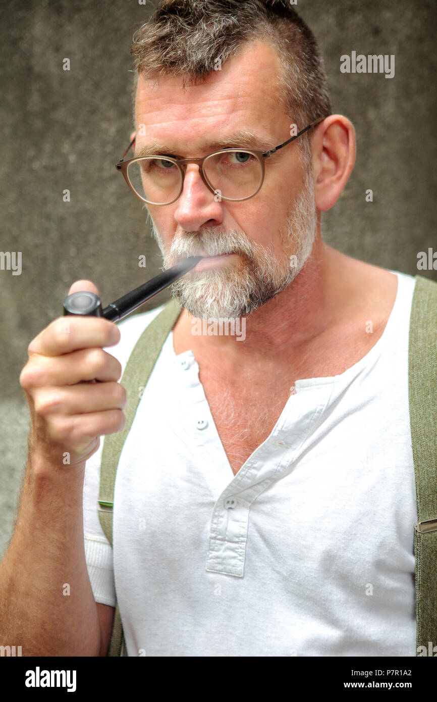 portrait of handsome bearded man in his 50s smoking a pipe Stock Photo ...