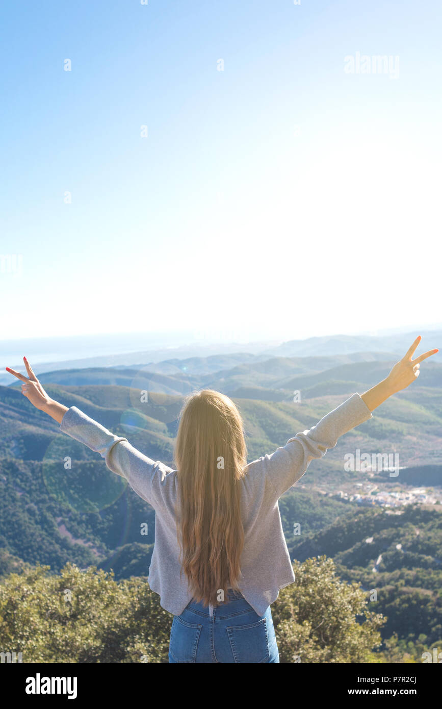 Beautiful women showing peace sign while enjoying mountains landscape ...