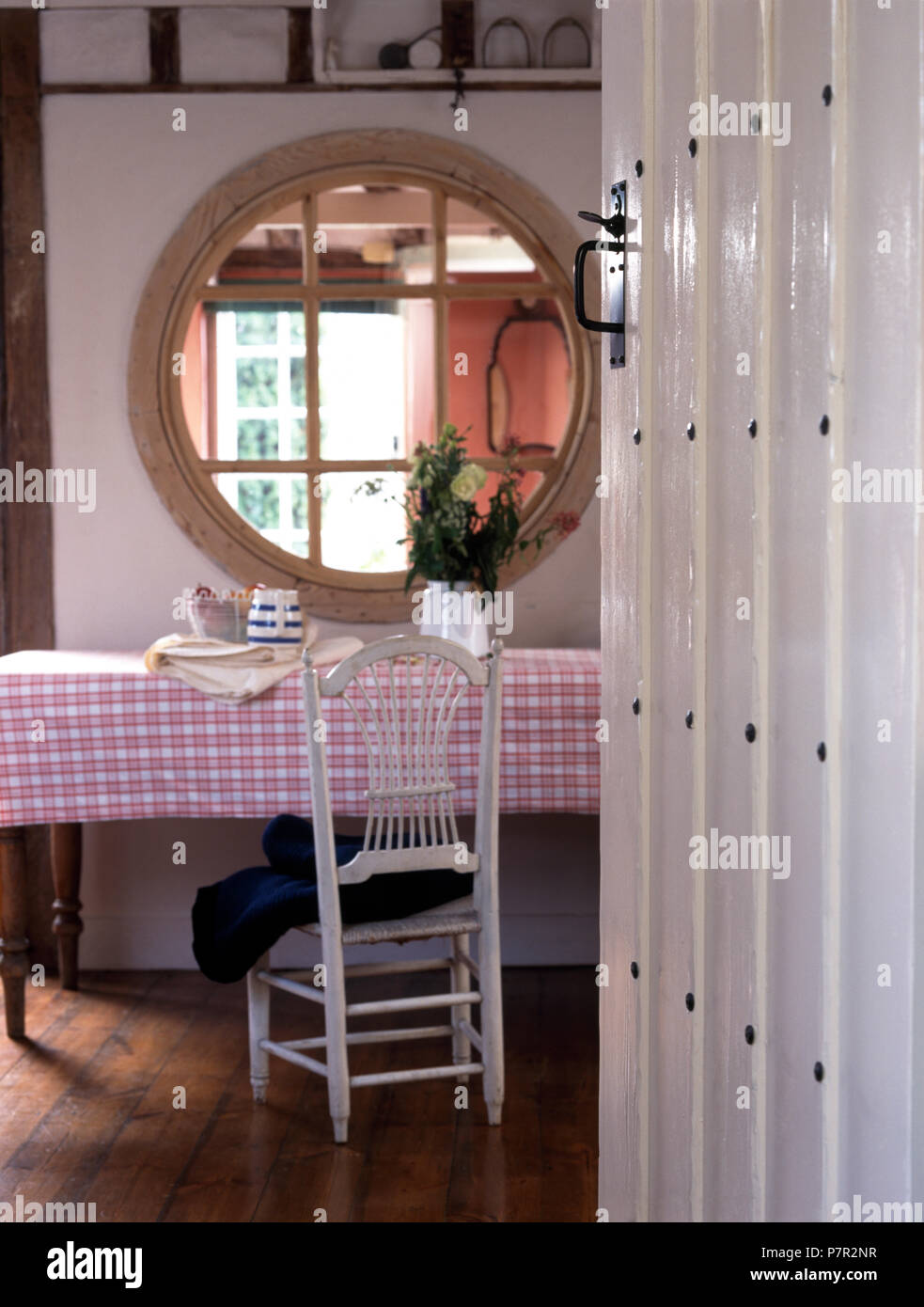 White painted door open to cottage dining room with a circular interior ...