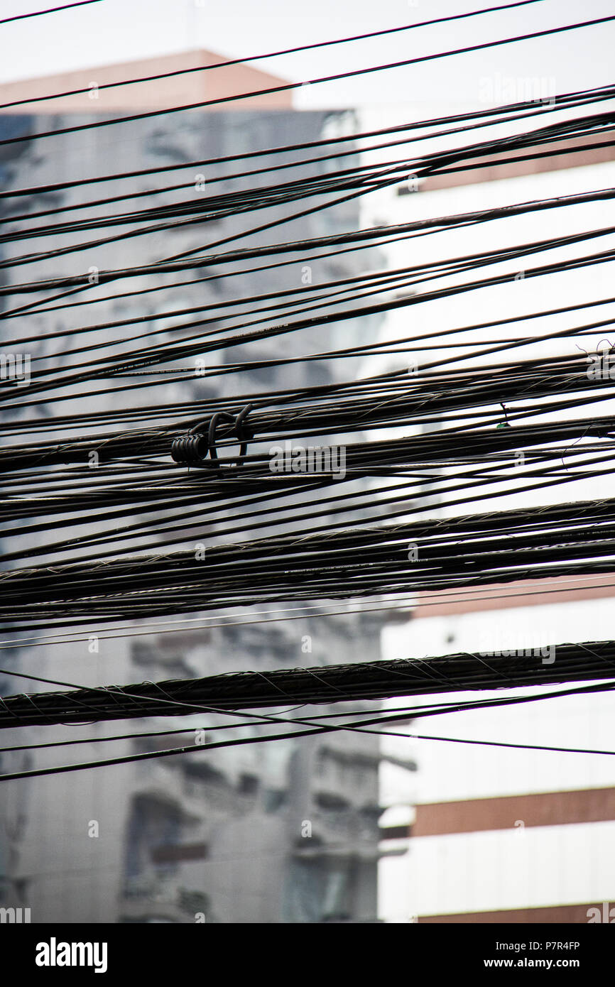 Electric wires detail with modern corporate building on the background ...