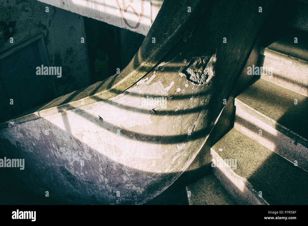 Detail of a vintage cracked concrete spiral staircase in a ruined ...