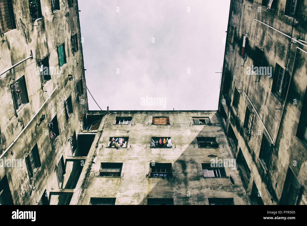 Low angle view of a ruined c shape building with square windows used by ...