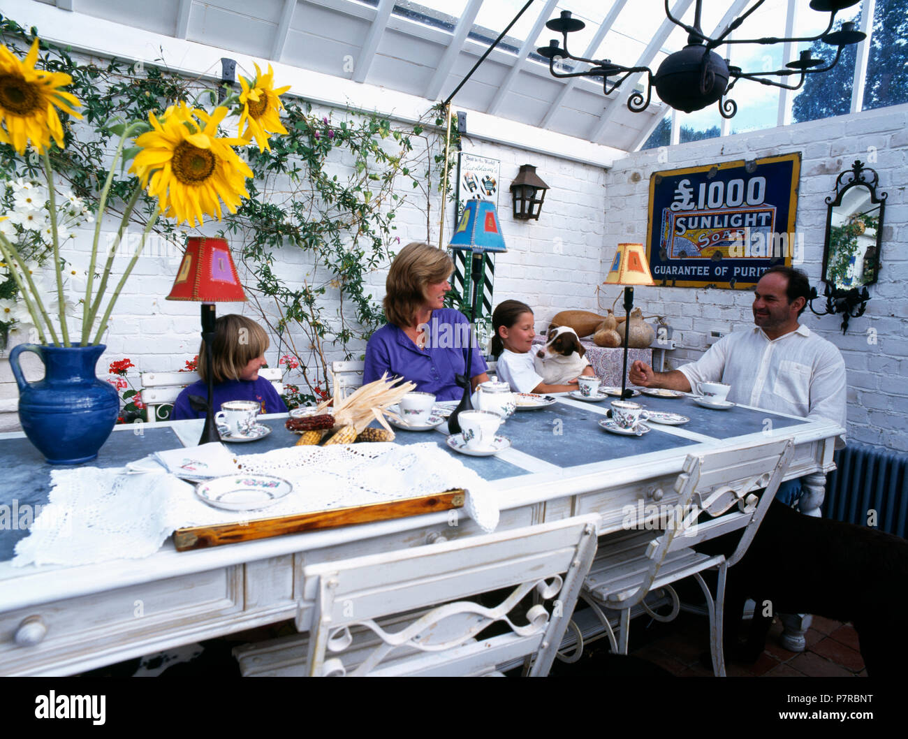 Young family having lunch in conservatory dining room FOR EDITORIAL USE ...