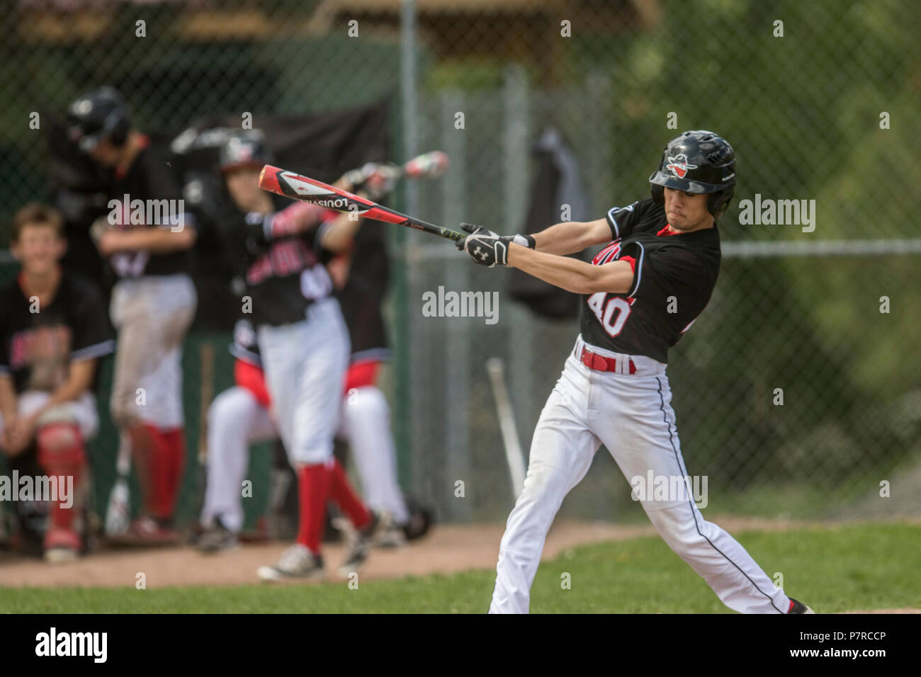 Batter swinging at baseball, boys afternoon junior baseball game ...