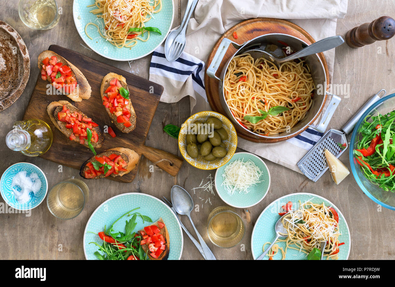 Italian dinner table with pasta, appetizers and white wine, top view ...