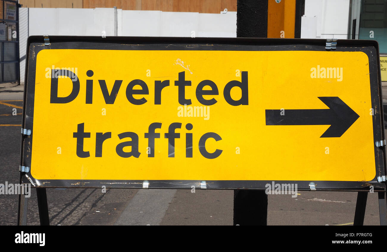 Diverted traffic direction sign, black text over yellow Stock Photo - Alamy