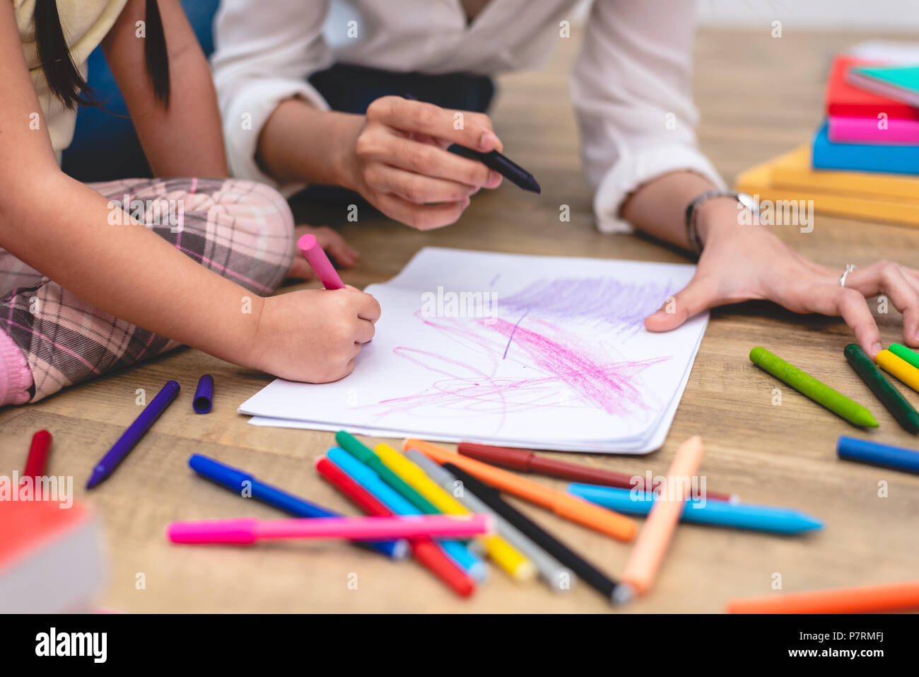 Closed up hands of mom teaching little children to drawing cartoon in ...