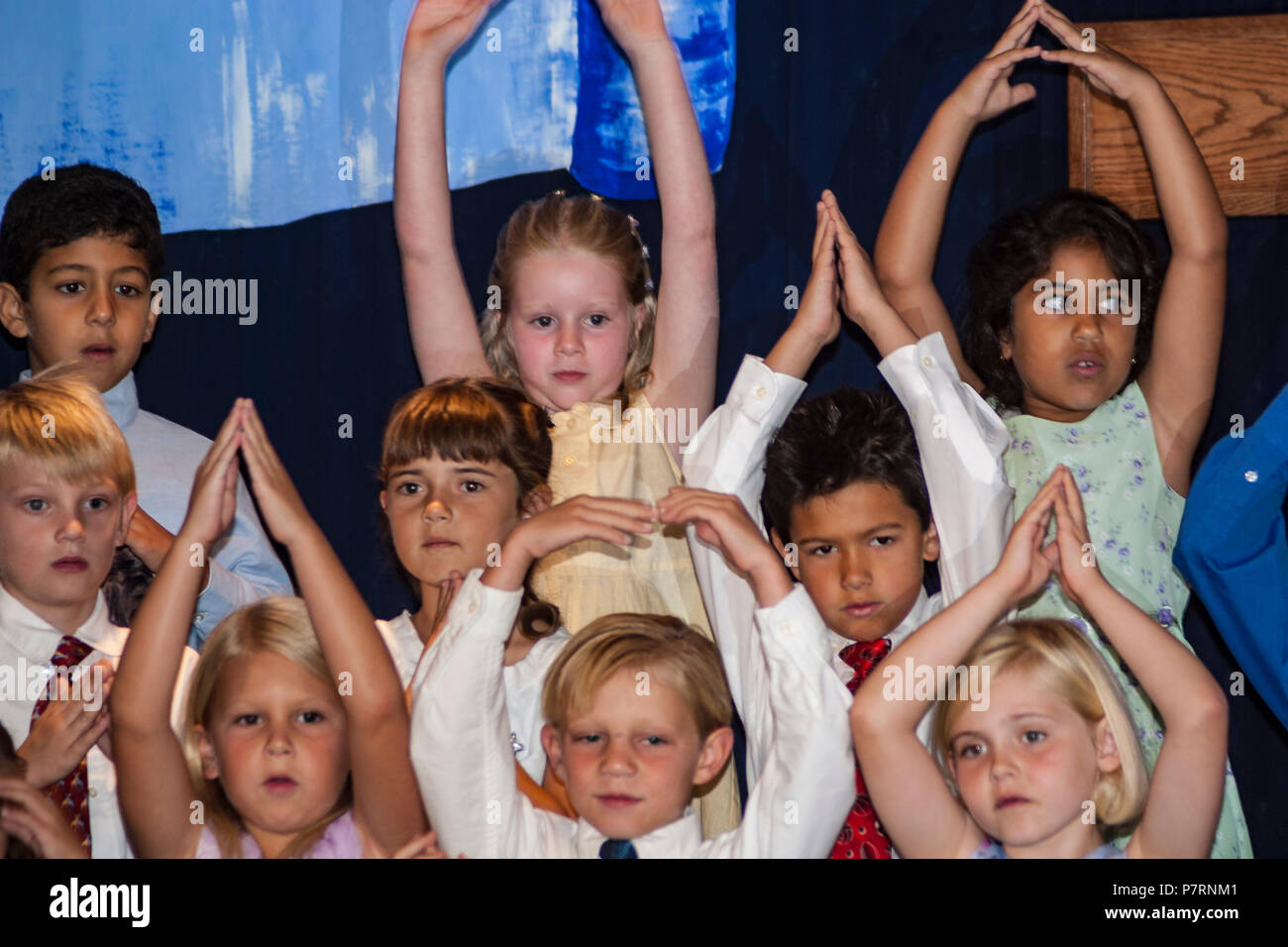 Group of Kindergarten kids perform for parents in audience. © Myrleen ...