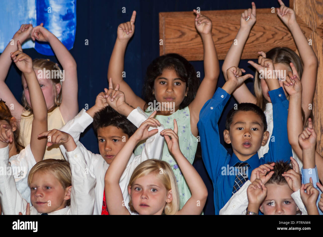 Group of Kindergarten kids perform for parents in audience. © Myrleen ...