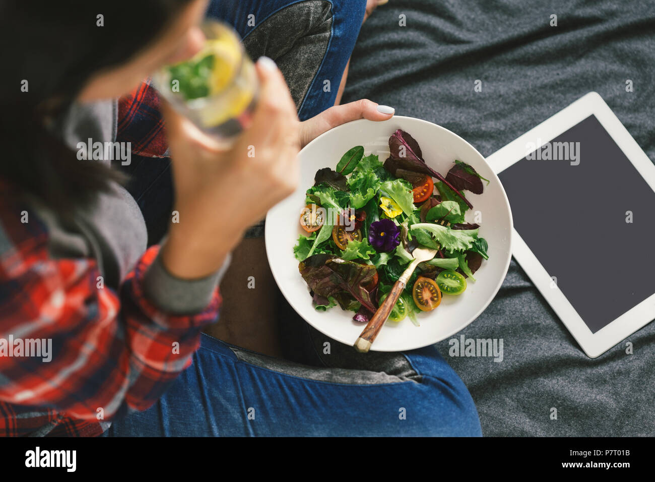 Healthy food concept. Top view young woman eating salad and drinks ...