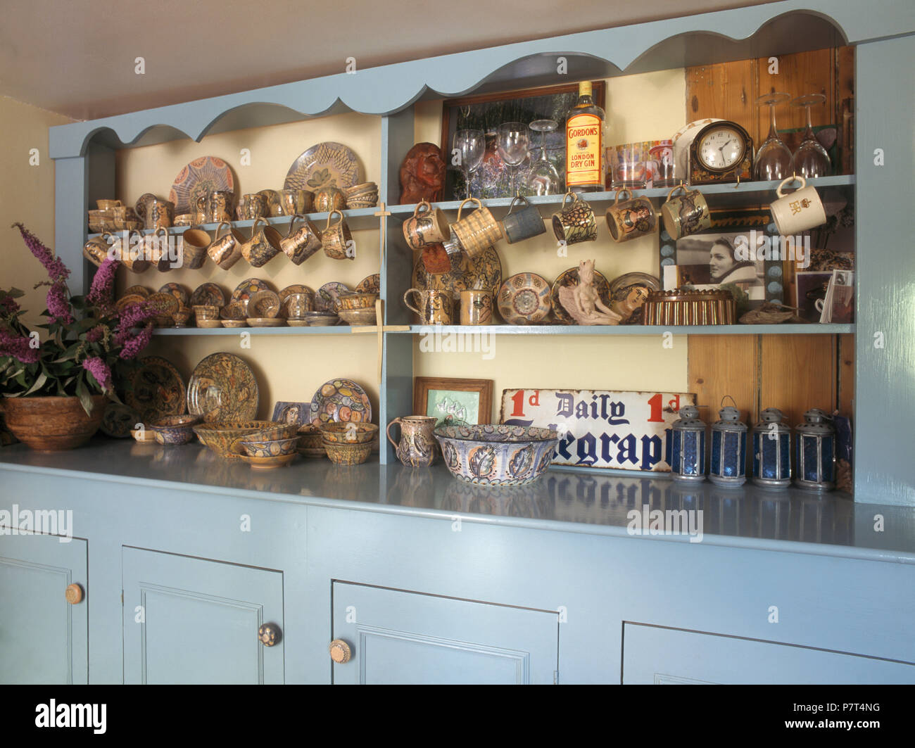 Collection of rustic pottery on blue shelves Stock Photo - Alamy