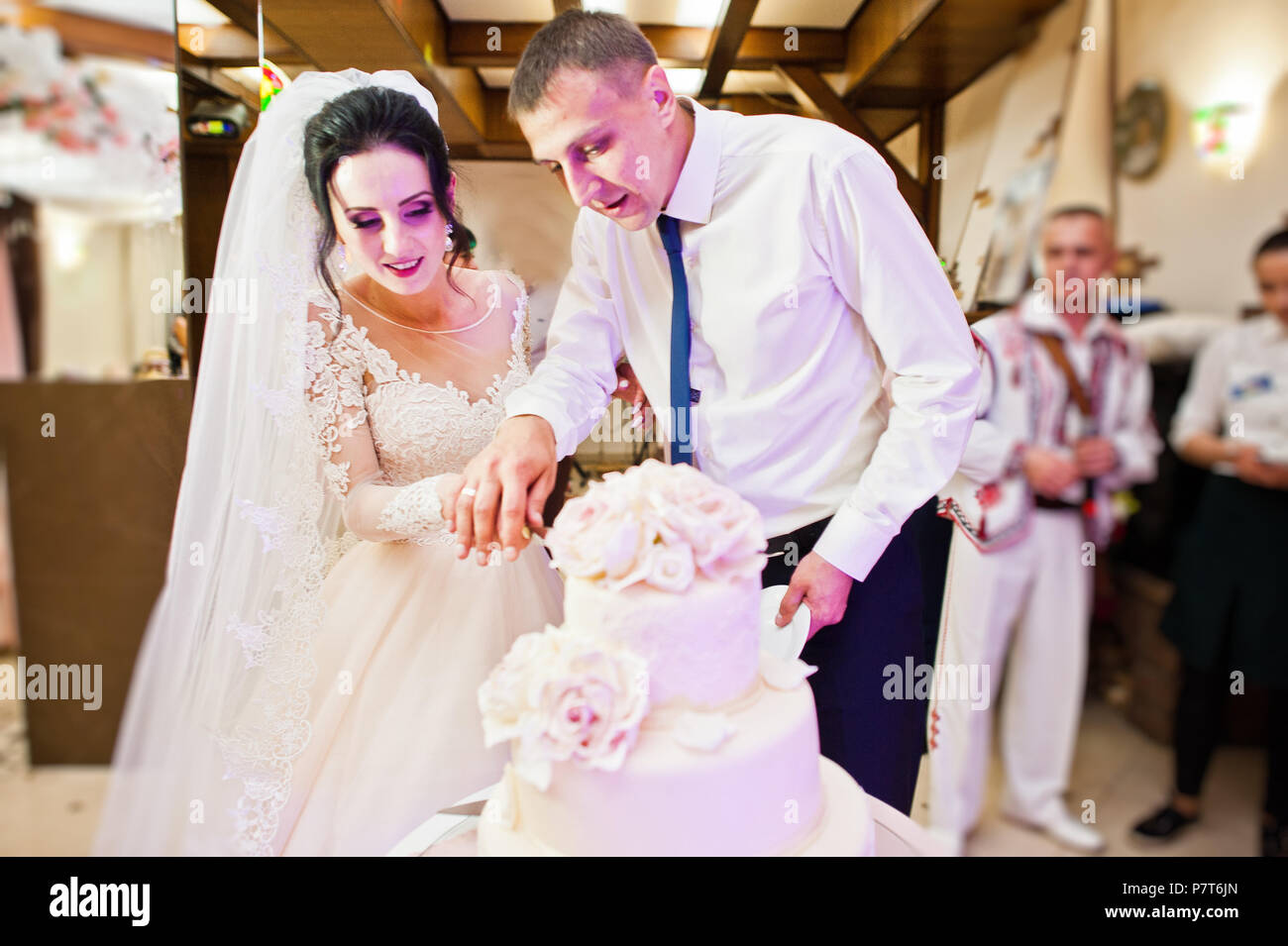 Wedding couple cutting their gorgeous white wedding cake in the ...