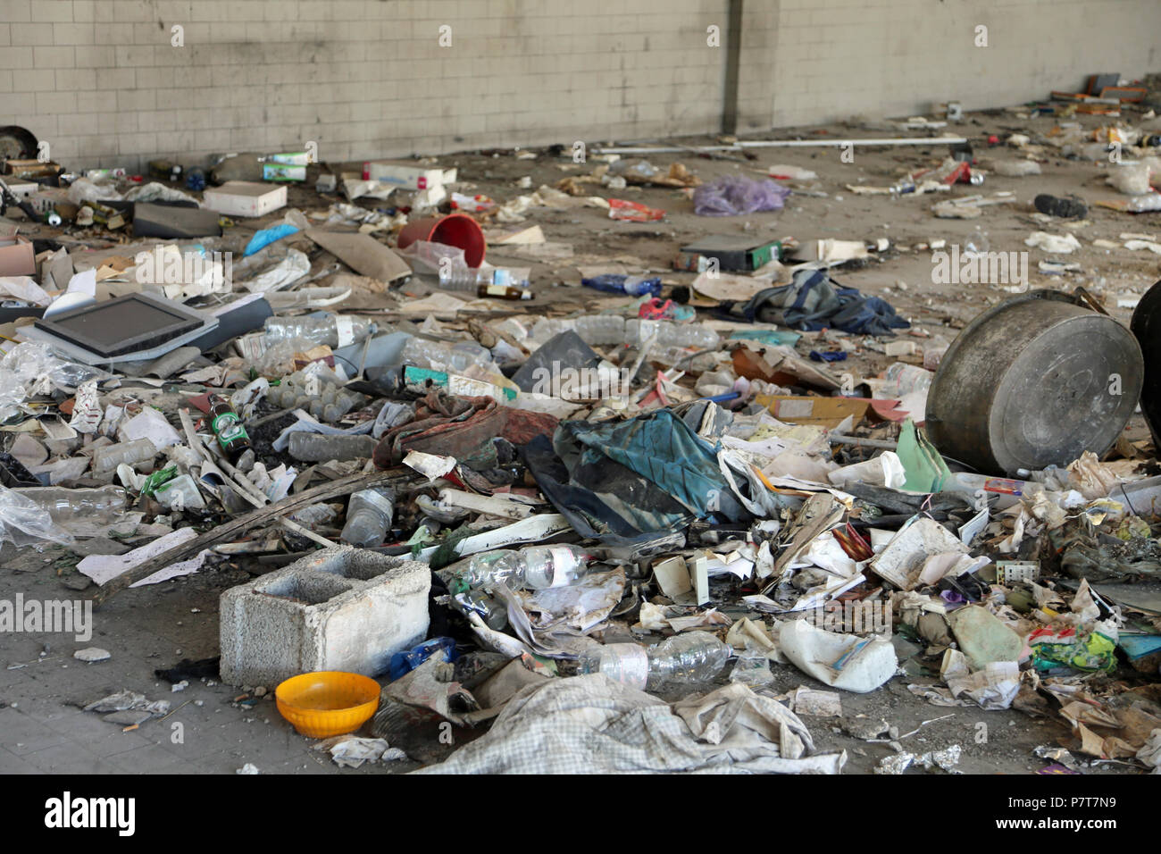 homeless shelter without people and many broken objects and dirty rags ...