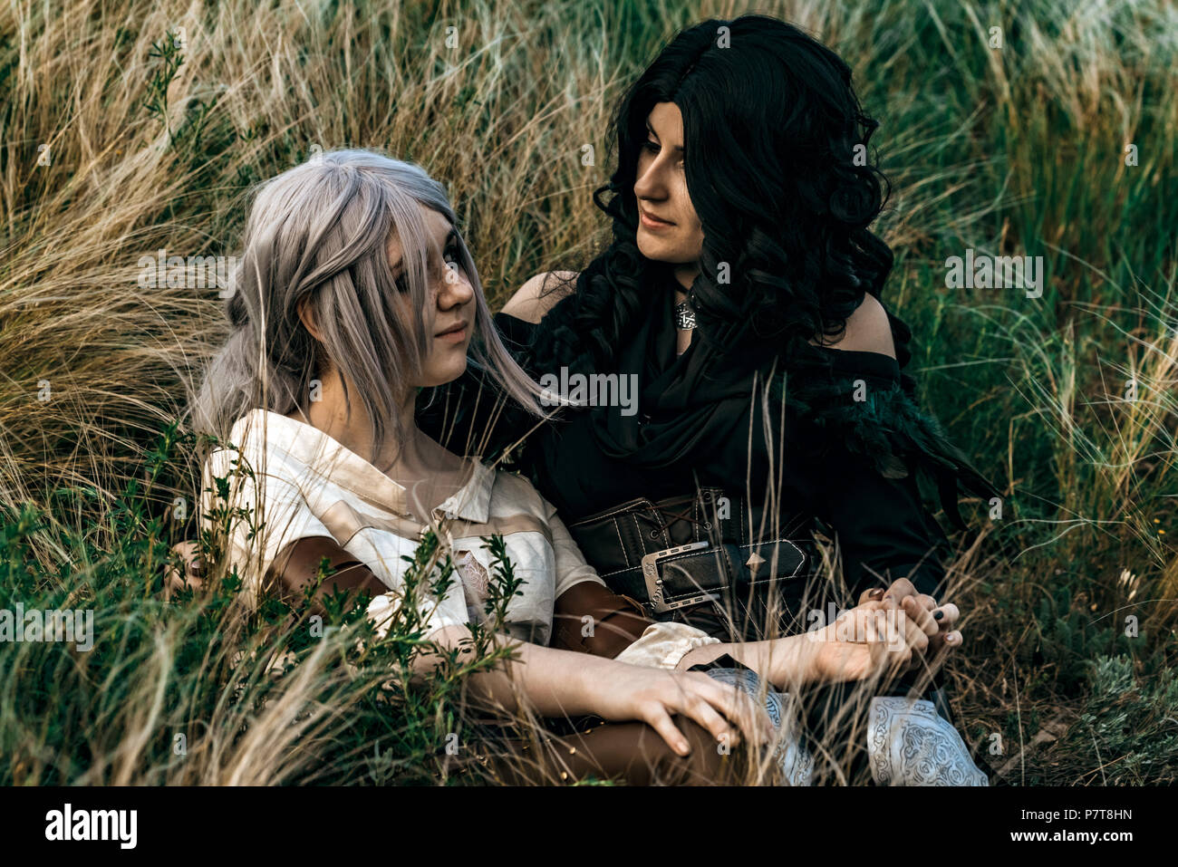 Fantasy cosplay two beautiful sit together in grass Stock Photo - Alamy