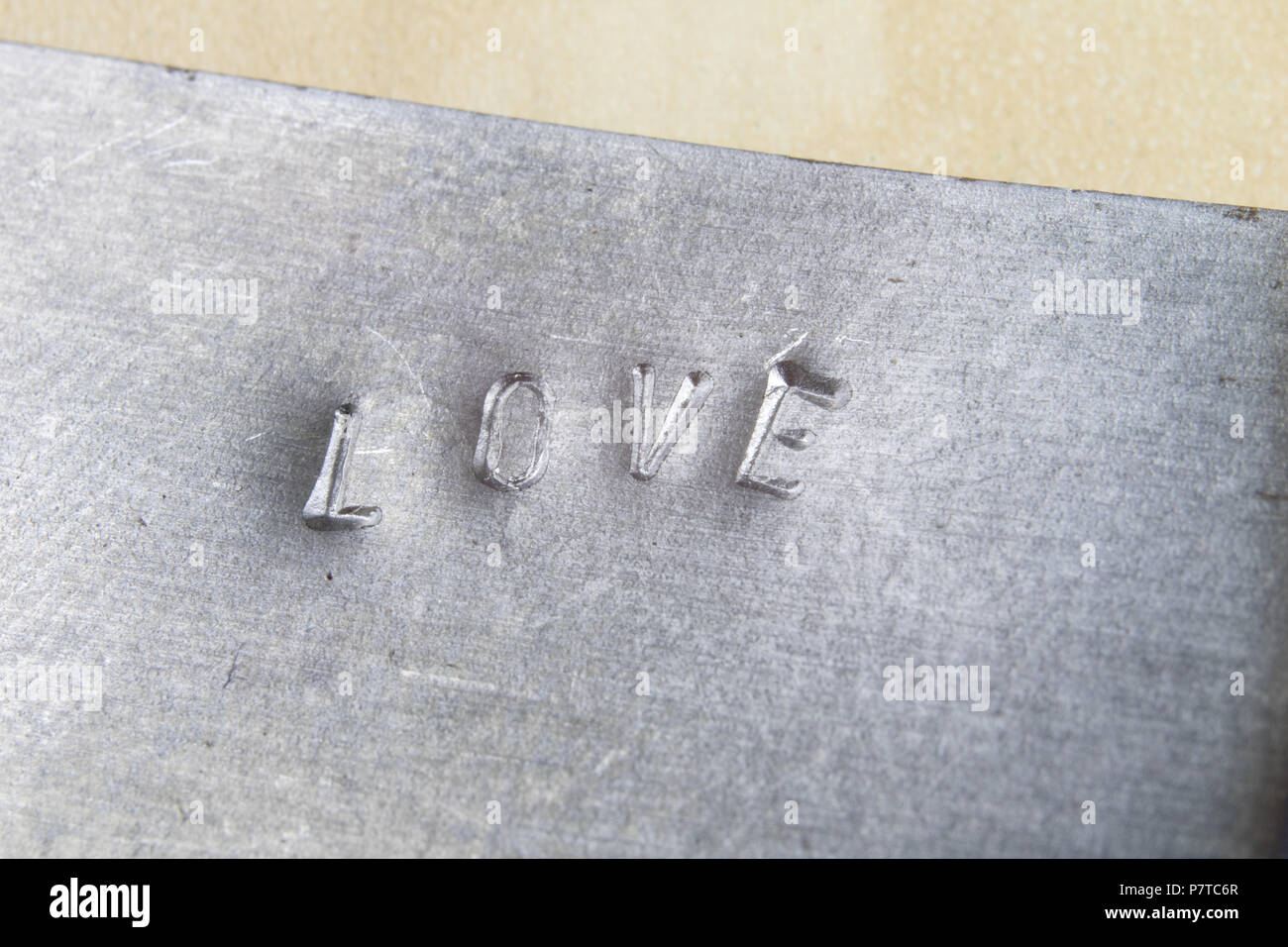 Embossed LOVE inscription in metal. The inscription on metal plates ...