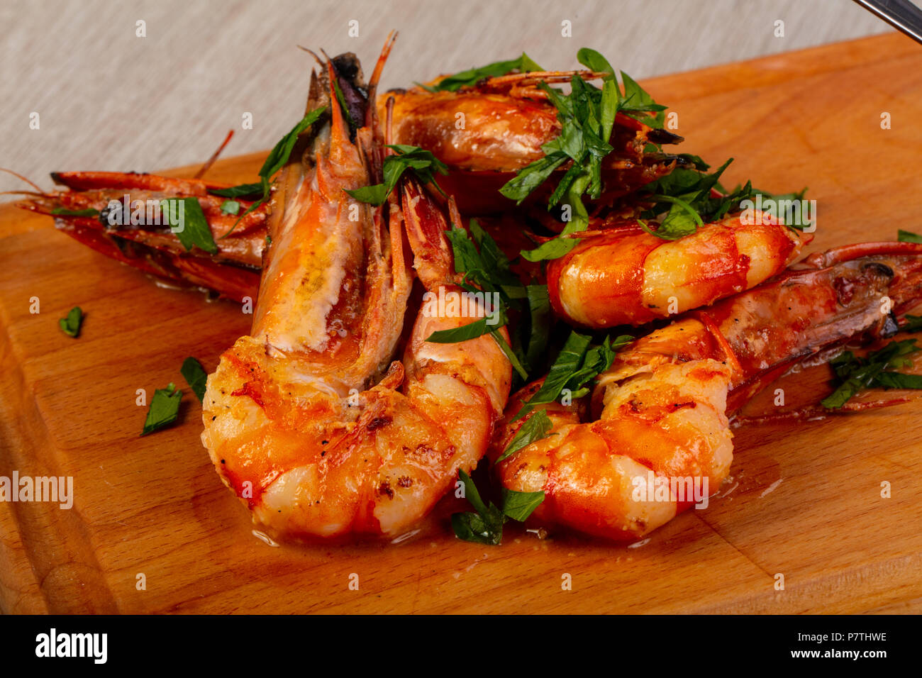 Grilled tiger prawns with herbs over wooden Stock Photo - Alamy