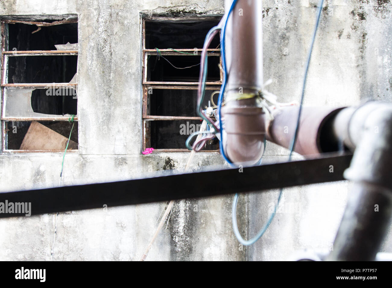 Water pipes trough decayed windows Stock Photo - Alamy