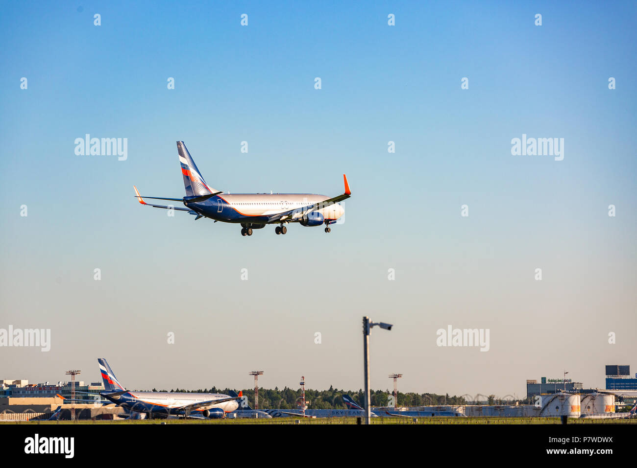 Passenger plane flying goes on takeoff in the blue sky Stock Photo - Alamy