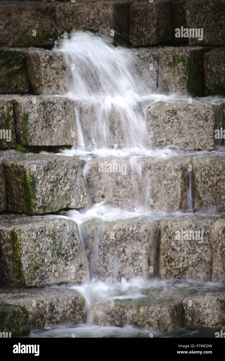 Water flows down the stone steps of a well Stock Photo - Alamy