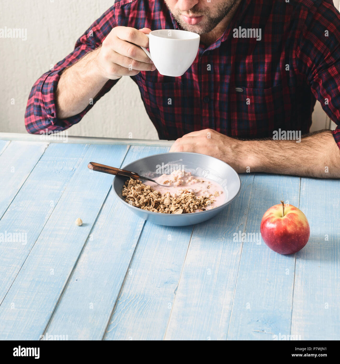 Healthy food concept. Man eating healthy breakfast in the kitchen at ...