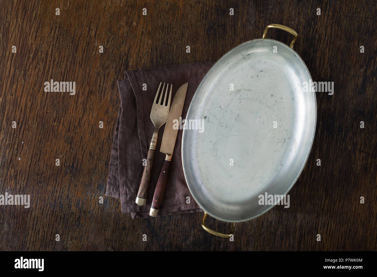 Vintage frying pan with knife and fork on wooden background, top view ...