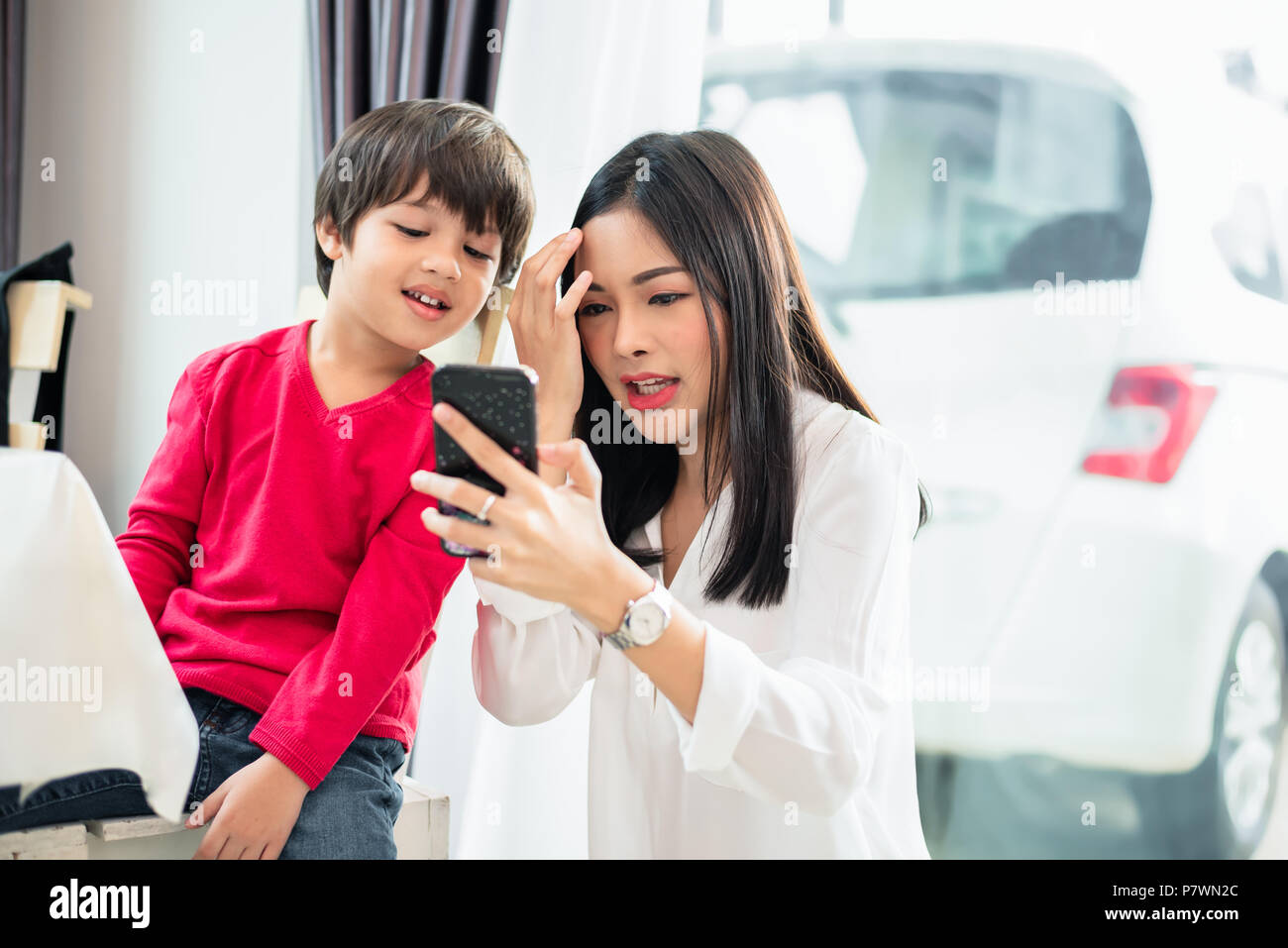 Mom and her child using and looking into smartphone together. People ...