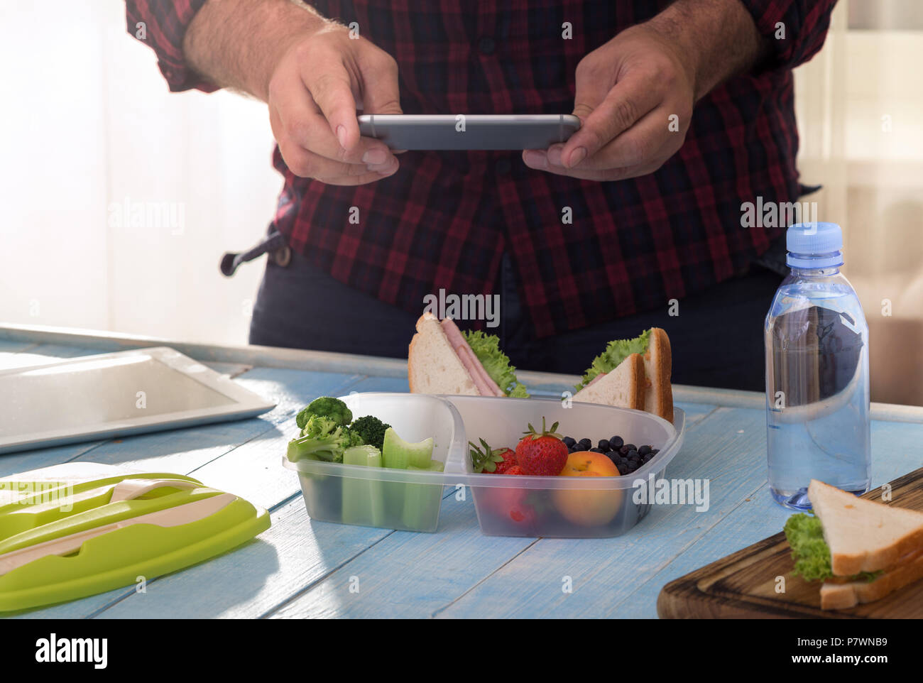 Man photographing lunch box with healthy food Stock Photo - Alamy