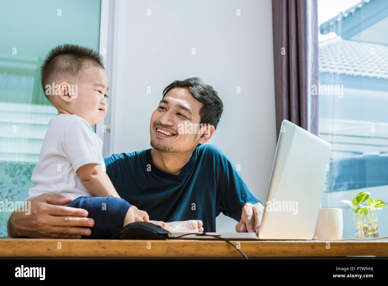 Single dad and son using laptop together happily. Technology and ...
