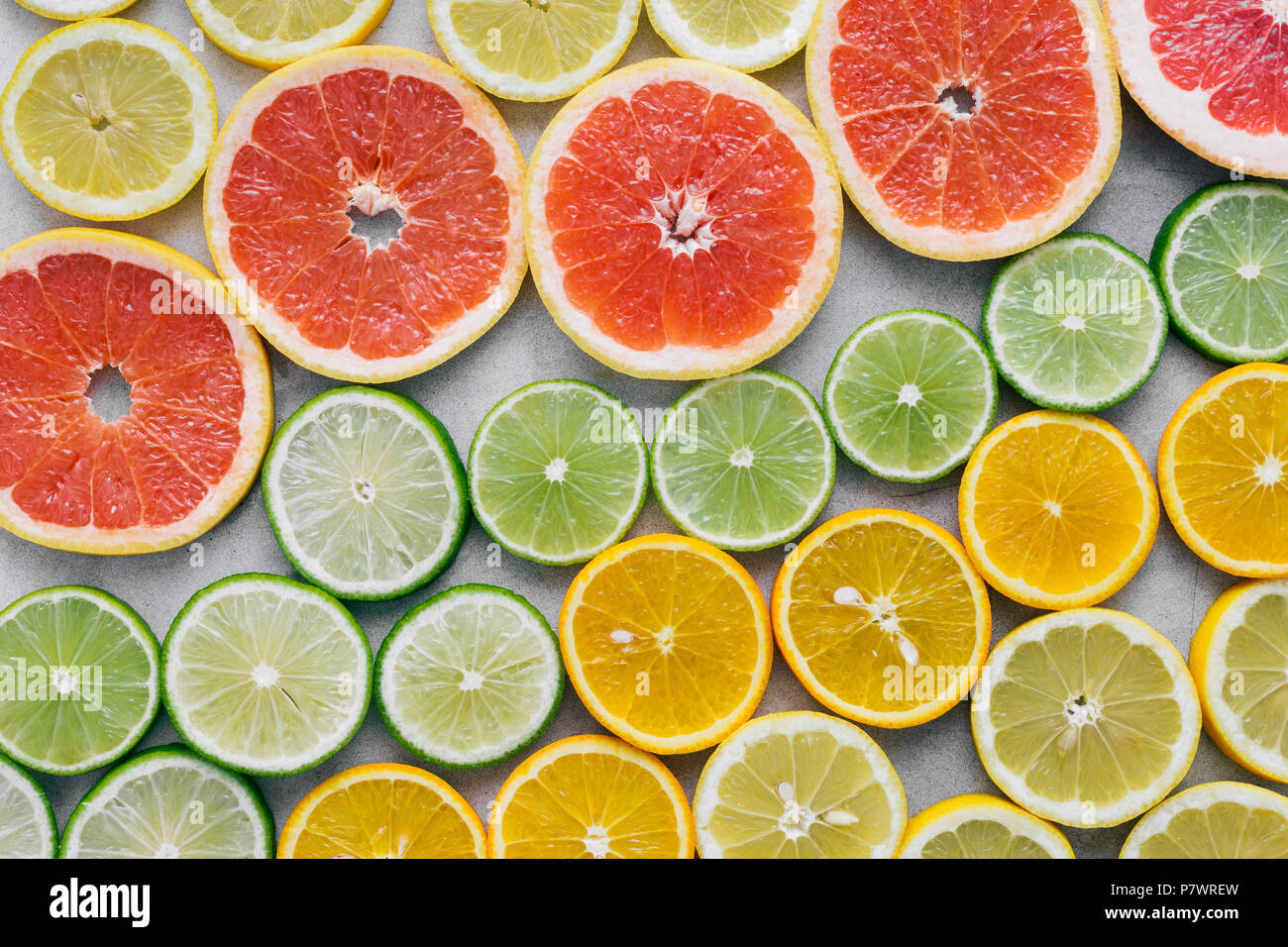 Top view of sliced citrus fruit on light background close up. Flat lay ...