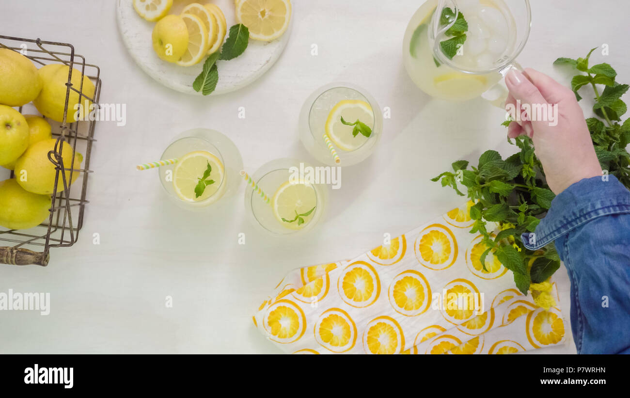 Step by step. Garnishing traditional fresh lemonade with lemon slices ...