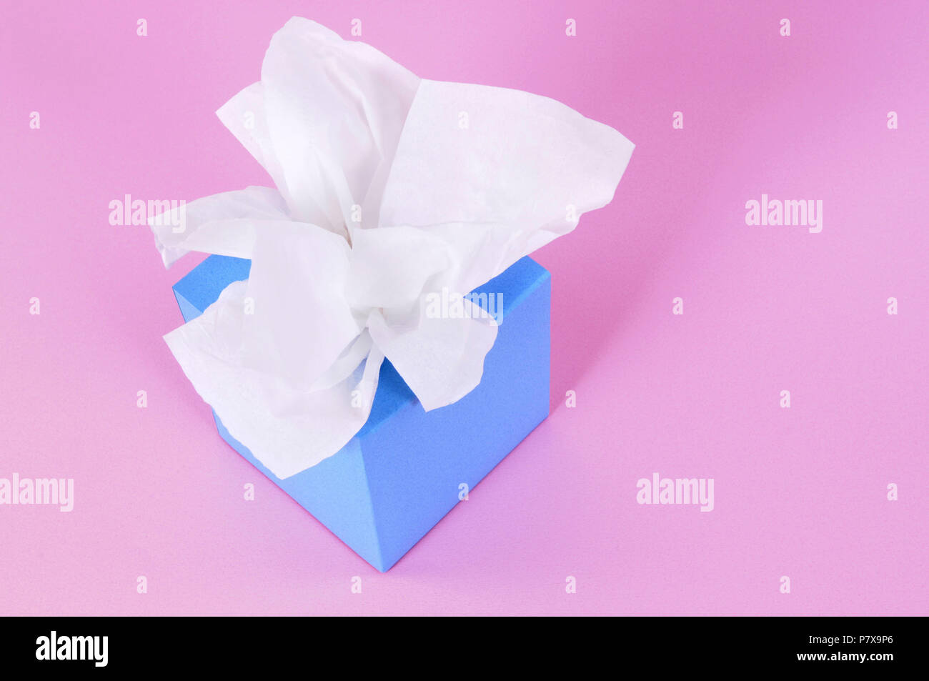 Kleenex style tissues in blank blue box on a pink background Stock ...