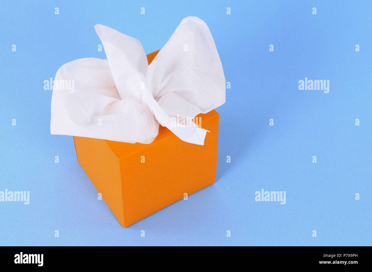 Kleenex style tissues in blank orange box on a blue background Stock ...