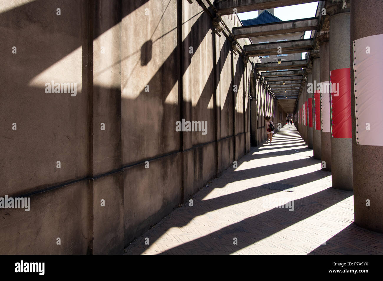 Long shadows on the pavement left by pillars and girders on a bright ...