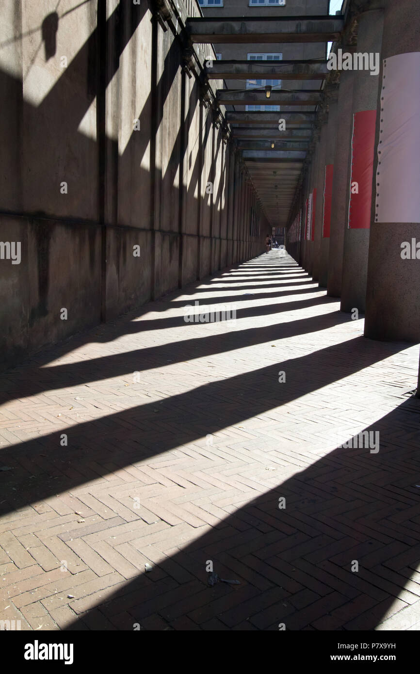 Long shadows on the pavement left by pillars and girders on a bright ...