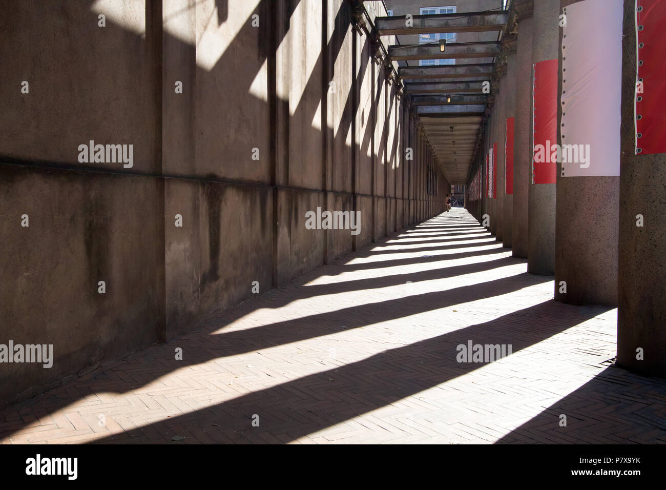 Long shadows on the pavement left by pillars and girders on a bright ...