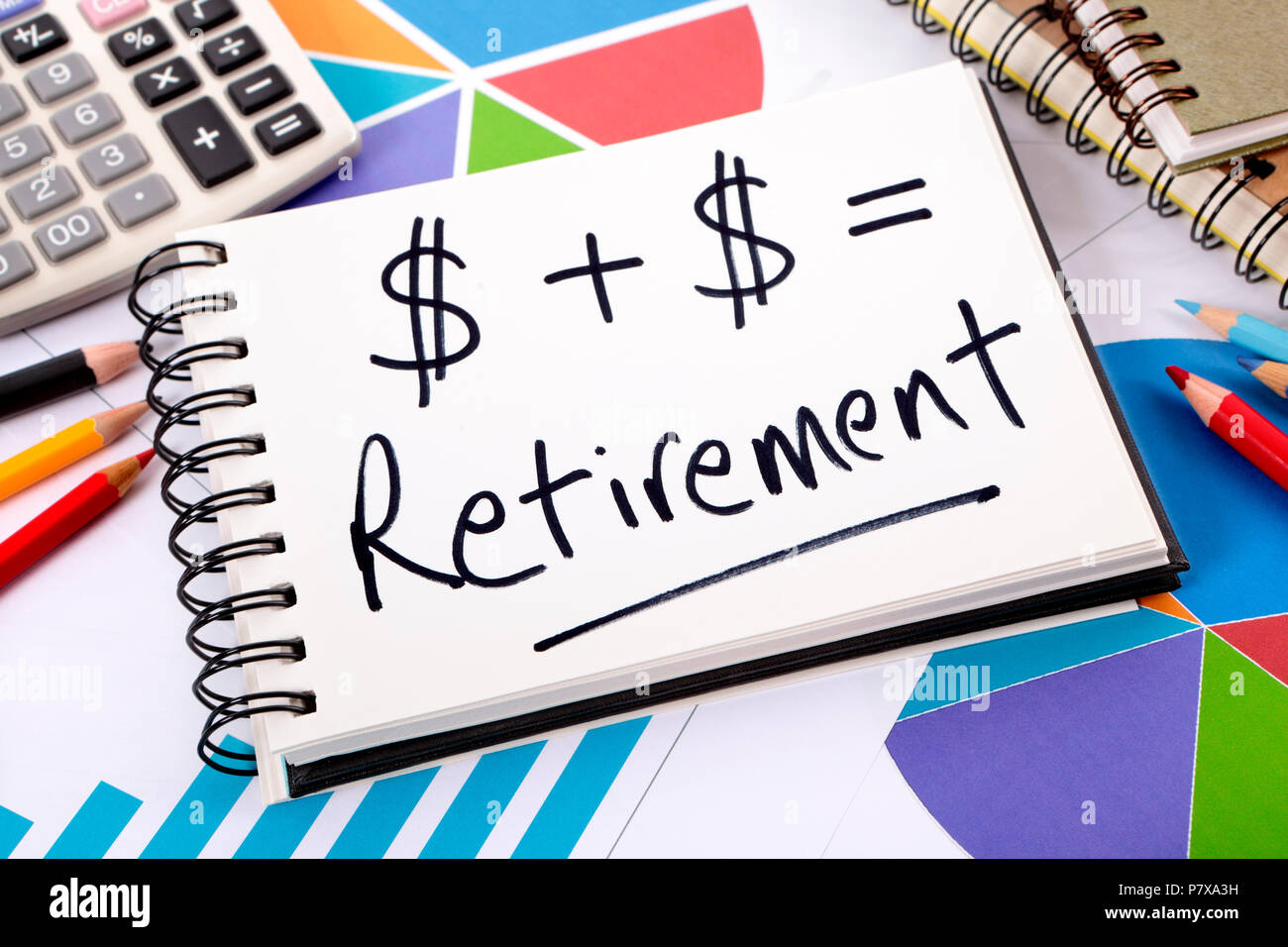 Simple retirement formula written on a notepad surrounded by graphs ...