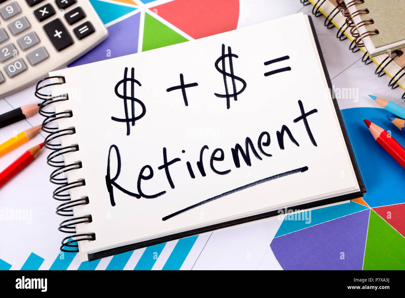 Simple retirement formula written on a notepad surrounded by graphs ...