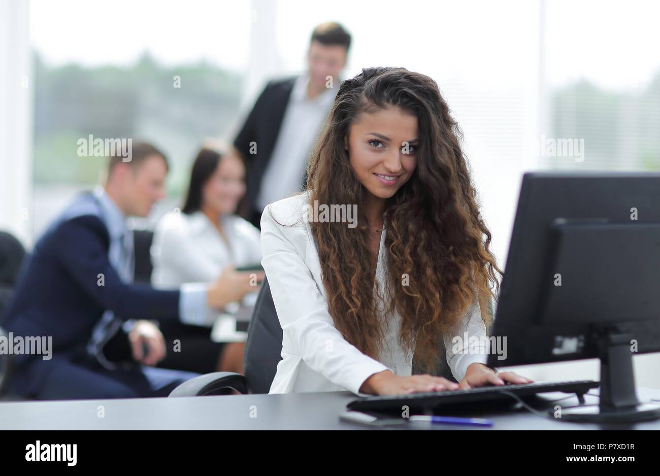 Manager woman sitting behind a Desk Stock Photo - Alamy