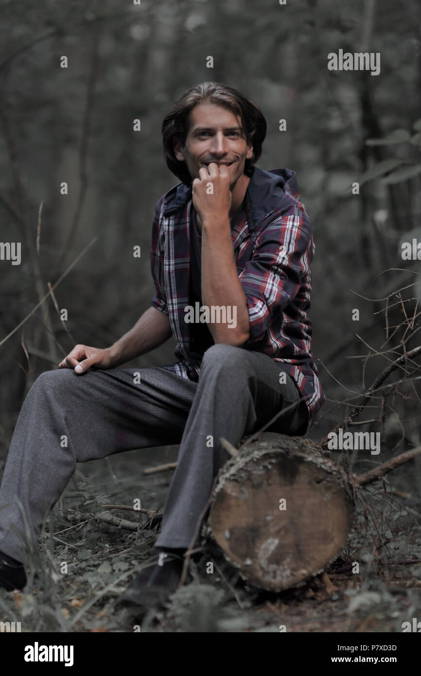dreaming of a man sitting on a log in the woods Stock Photo - Alamy