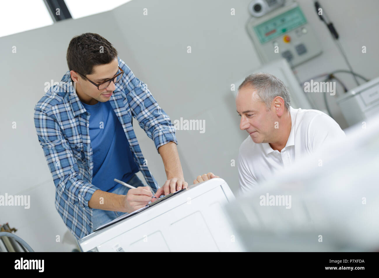 washing machine engineer filling in paperwork Stock Photo - Alamy