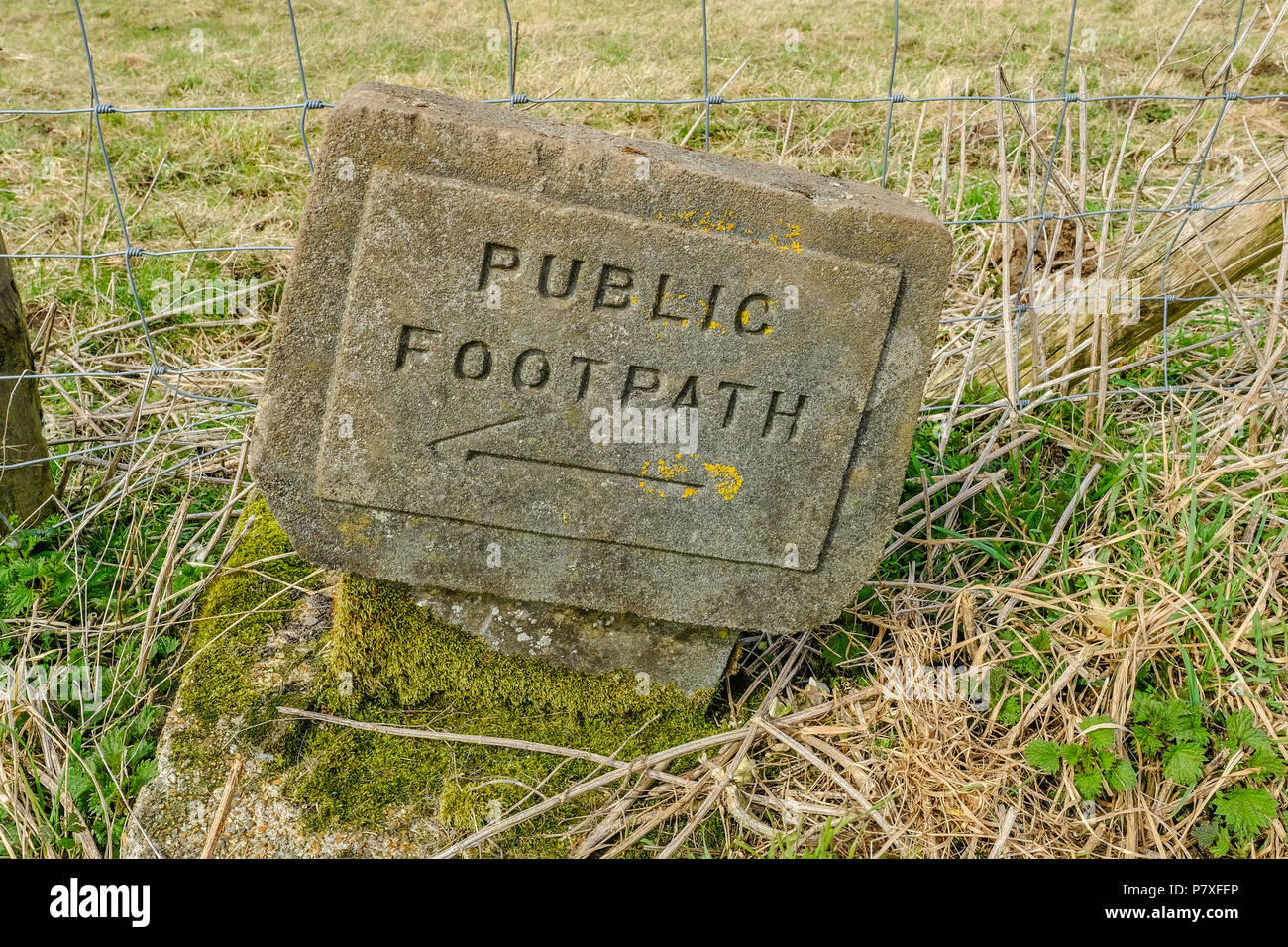 Old stone direction sign showing a Public Footpath with an arrow. Aged ...