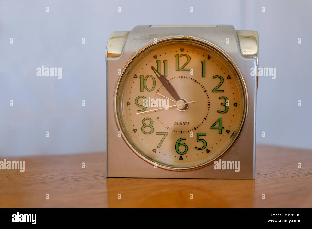 Antique alarm clock on a plain background. Luminous numbers and classic ...