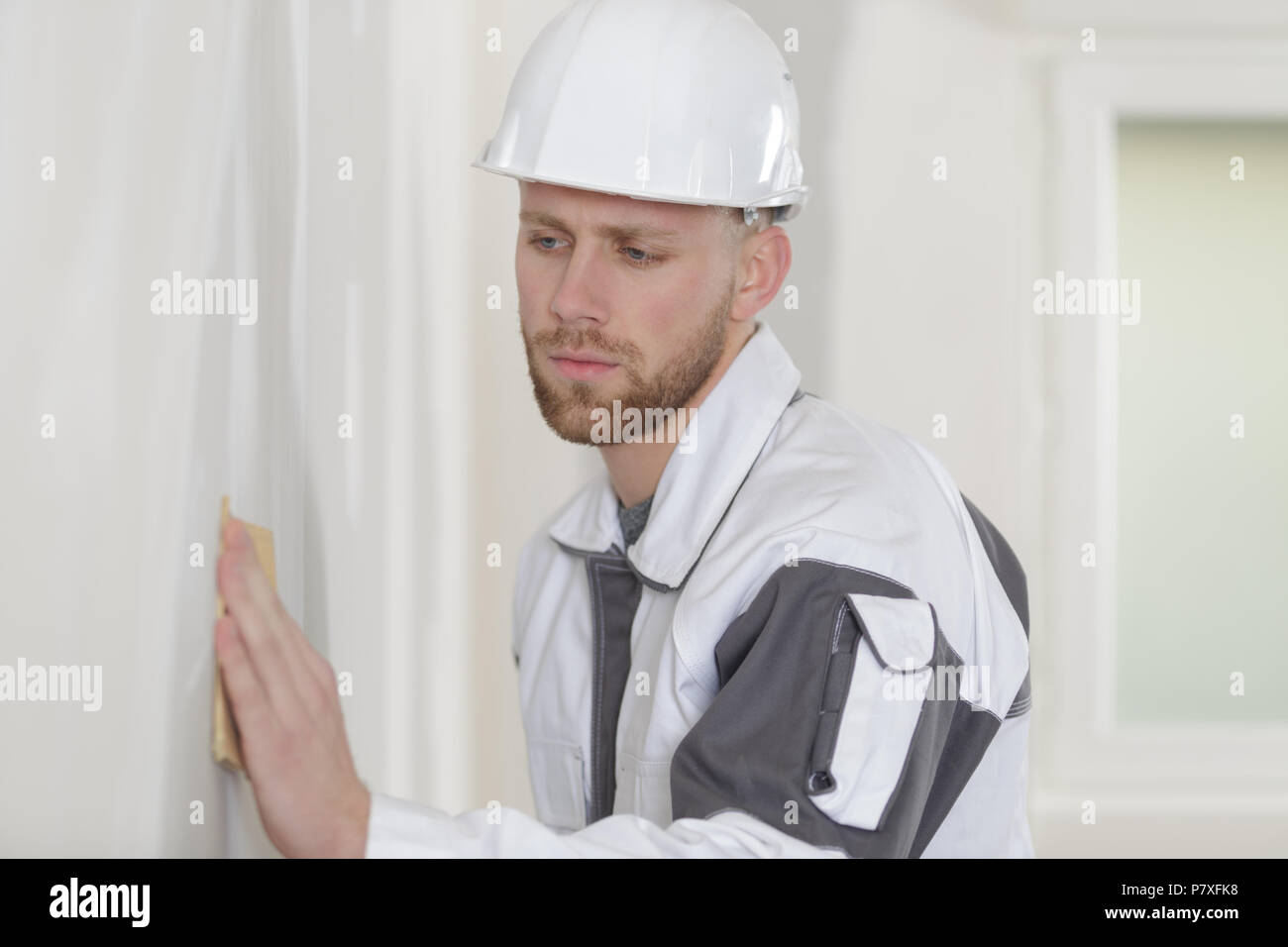 builder polishing a wall with sandpaper Stock Photo - Alamy