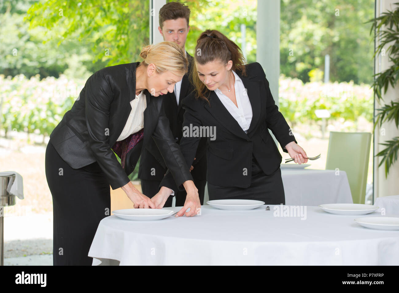 waitress with manager setting the table in a restaurant Stock Photo - Alamy