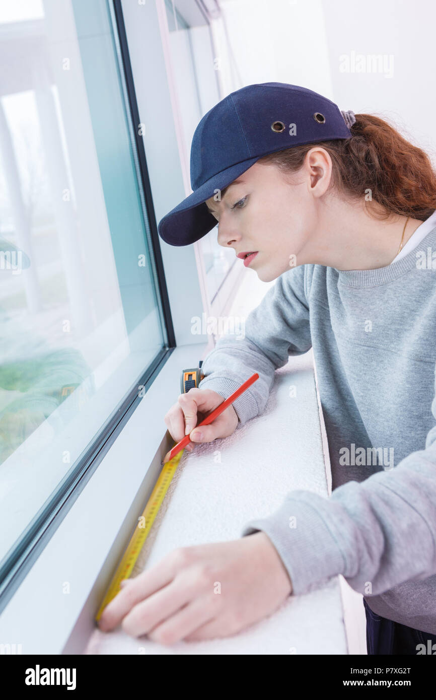 female using tape measure the window in construction site Stock Photo ...