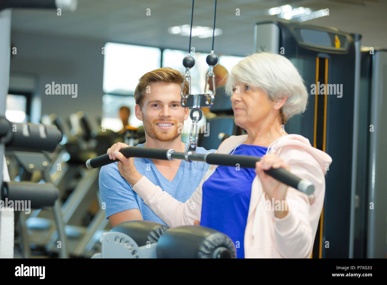 personal trainer with elderly woman in gym Stock Photo - Alamy
